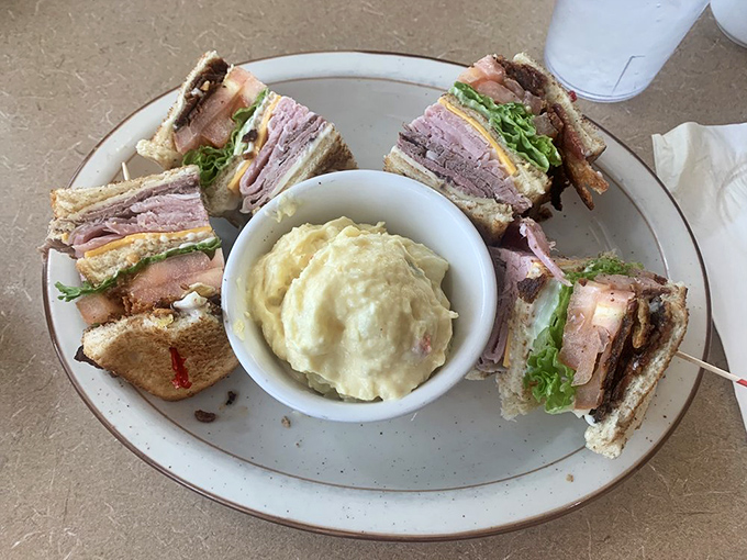 The club sandwich—architecture you can eat! Layers of deli perfection surrounding potato salad that didn't come from any plastic container.