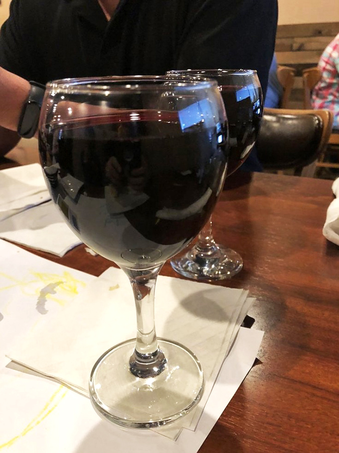 A glass of robust red wine stands ready for duty. In the battle against mundane weeknights, this is your delicious weapon of choice.