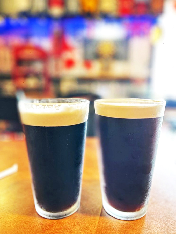 Two pints of dark perfection, because proper fish and chips deserve equally proper liquid accompaniment.