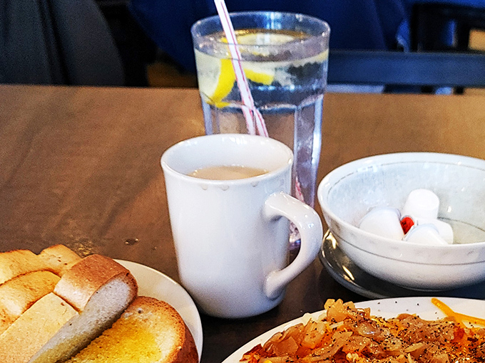The holy trinity of diner refreshment: strong coffee, ice water with lemon, and the promise of refills without judgment.