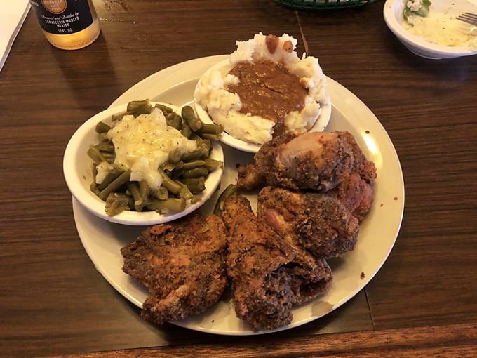 The holy trinity of Midwest comfort: perfectly fried chicken, green beans that actually taste like vegetables, and mashed potatoes with a gravy lake.