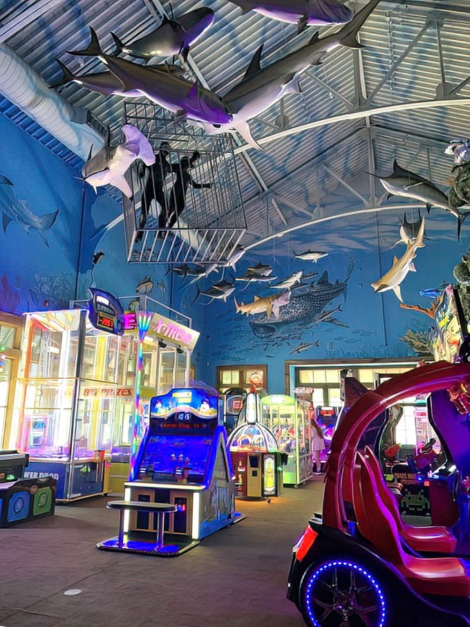 Sharks and game machines coexist peacefully under the blue lights. The only predators here are the ones gunning for the high score.