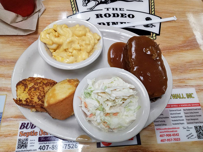 Comfort food gets the five-star treatment. Creamy mac and cheese, homestyle slaw, and cornbread alongside what appears to be meatloaf slathered in rich gravy.