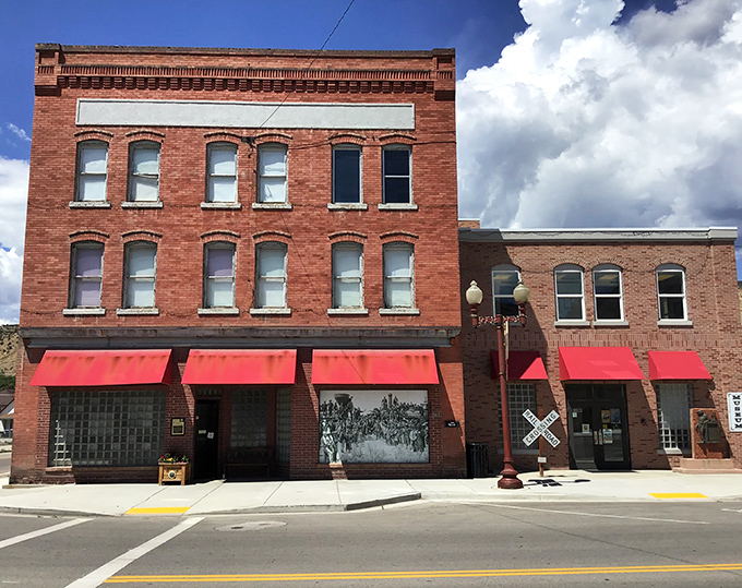 Historic storefronts with bright red awnings create a Main Street that Hollywood location scouts would kill to discover for their next period film.