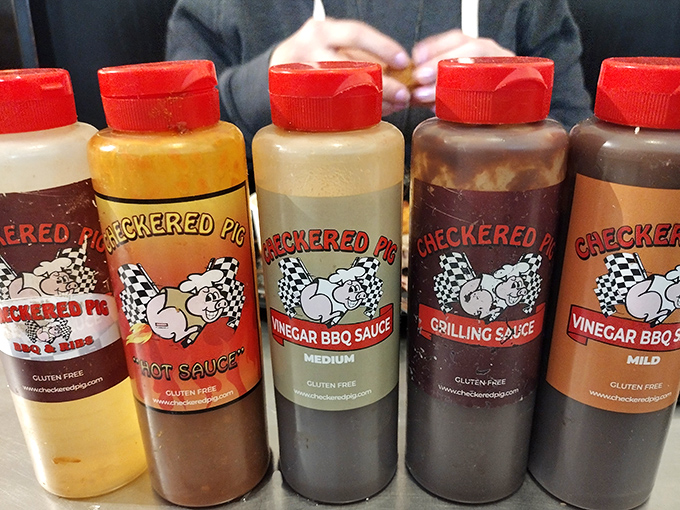 The sauce lineup looks like a chemistry experiment gone deliciously right. Each bottle contains liquid magic that transforms good barbecue into an out-of-body experience.