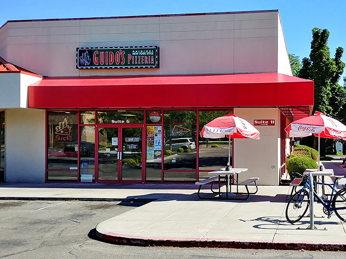 Guido's red awning and picnic tables channel that classic New York pizzeria vibe where the focus is on the pie, not the decor.