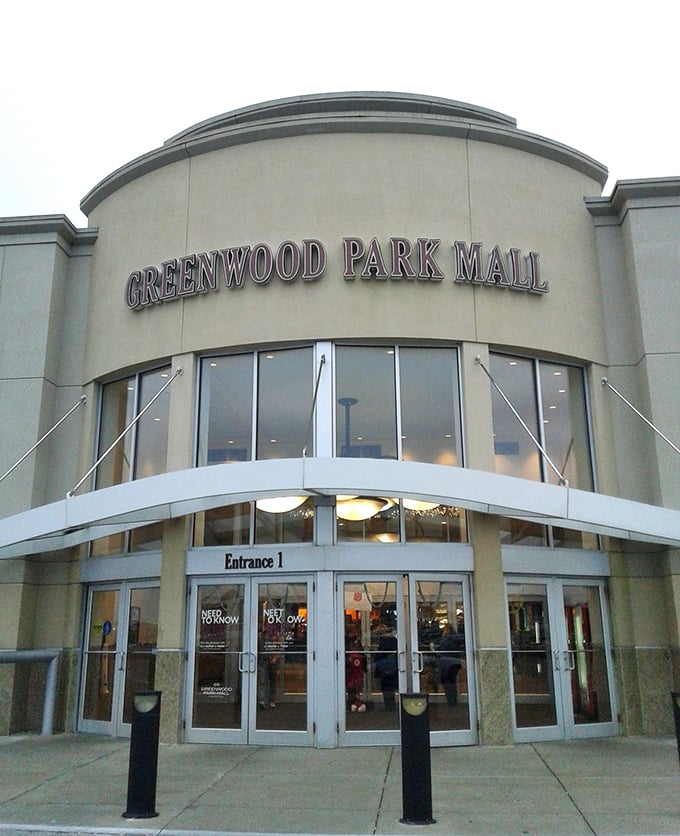 Evening lights illuminate Greenwood Park Mall's entrance, welcoming night owls to extended bargain hunting hours.