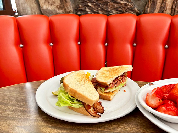 A proper BLT served against that iconic red vinyl&mdash;proof that three simple ingredients, when respected, can outshine the fanciest tasting menu.