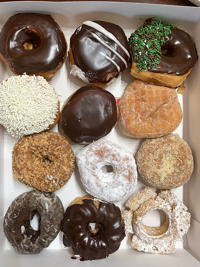 A holy trinity of donut perfection. The chocolate, powdered sugar, and sprinkled varieties represent the past, present, and future of breakfast indulgence.