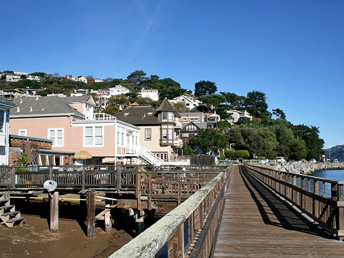 The weathered boardwalk stretches along the shoreline, connecting charming homes to the bay that serves as both their front yard and constant muse.