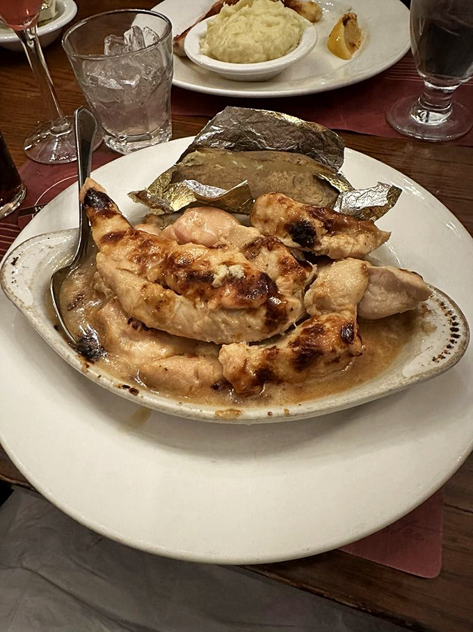 Broiled chicken bathing in savory juices with a baked potato standing guard. Proof that not everything delicious needs breading.