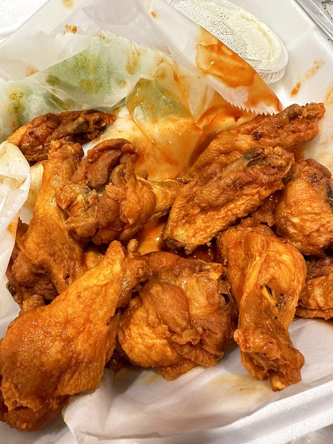 Buffalo wings glistening with sauce that strikes that perfect balance between sweet, tangy, and "please bring me napkins and another order."