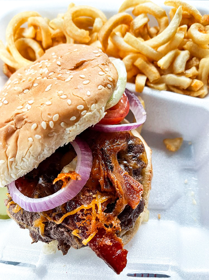 This isn't just a burger—it's a masterclass in American excess, with melted cheese cascading down the sides like lava from a delicious volcano.