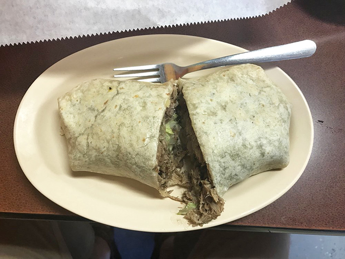 This burrito isn't just wrapped—it's embraced. Two perfect halves revealing the treasure within, like edible geometry that tastes better than it sounds.