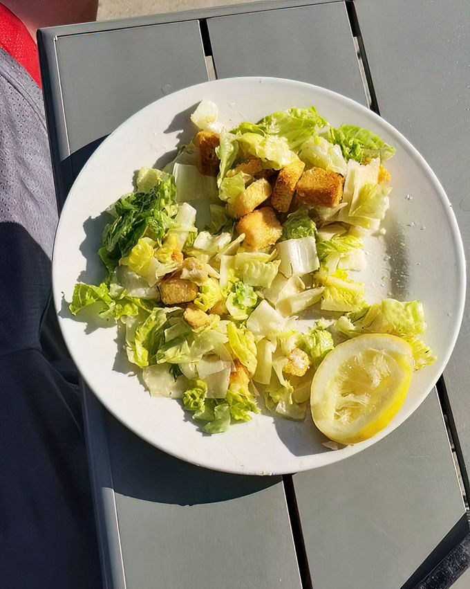 Caesar salad so fresh and bright it could convince a committed carnivore to consider a day without meat. That lemon wedge isn't just garnish&mdash;it's essential punctuation.