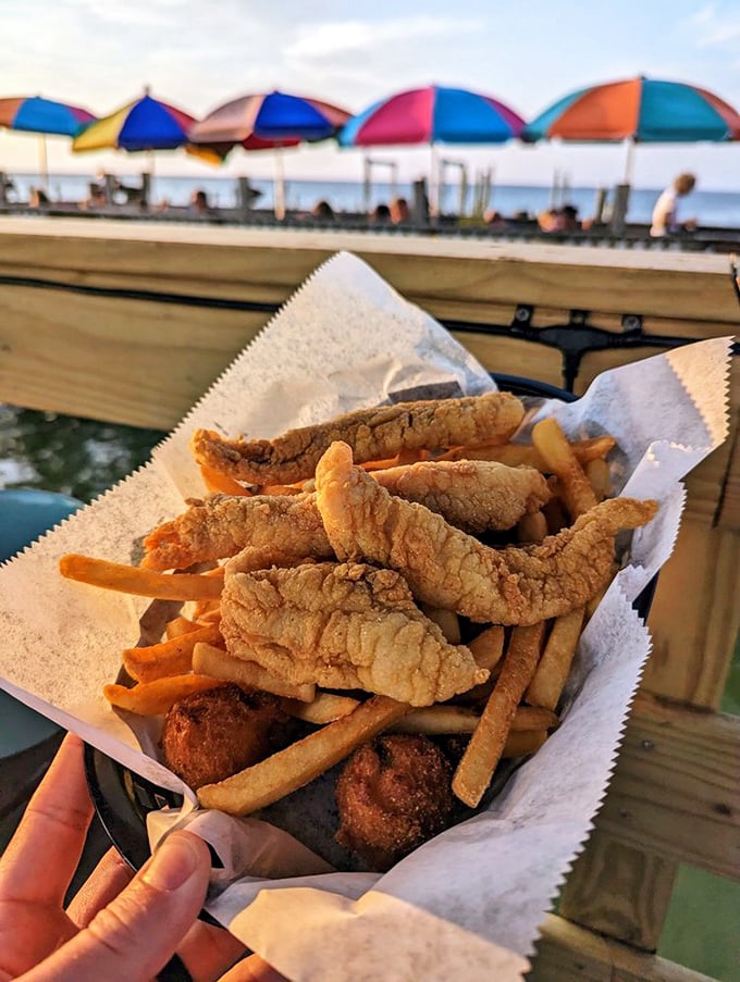 Fried catfish and fries with colorful umbrellas in the background&mdash;Florida's version of a perfect sunset dinner.