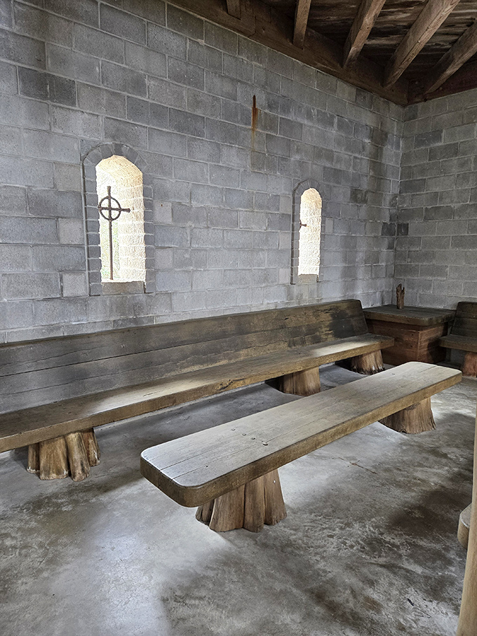 Simple wooden benches beneath narrow windows create a contemplative space where visitors can pause and absorb the castle's unique atmosphere.