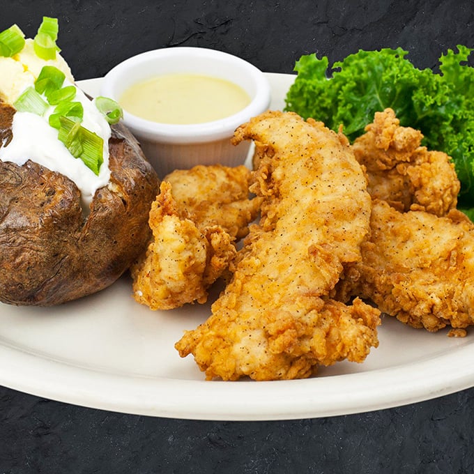 Golden-battered chicken tenders that actually taste like chicken, not just their crispy coating. That loaded baked potato is no mere sidekick.