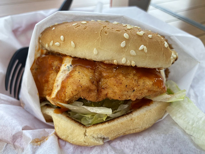 The Cluckster's golden-fried chicken gleams like treasure on a seeded bun, promising crunch that'll be heard three tables away.