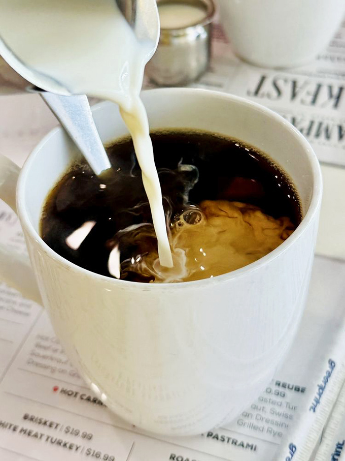 The perfect coffee pour &ndash; that mesmerizing dance of cream meeting dark brew. A necessary companion for bagel contemplation.