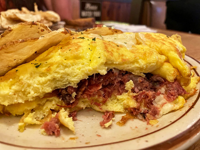 A cross-section revealing the inner architecture of a perfect corned beef hash omelet &ndash; a blueprint worth framing or, better yet, devouring.