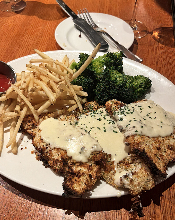 Crusted chicken that's having an identity crisis – thinks it's fried but dresses like it's baked. That cream sauce is playing favorites, and we're not complaining.