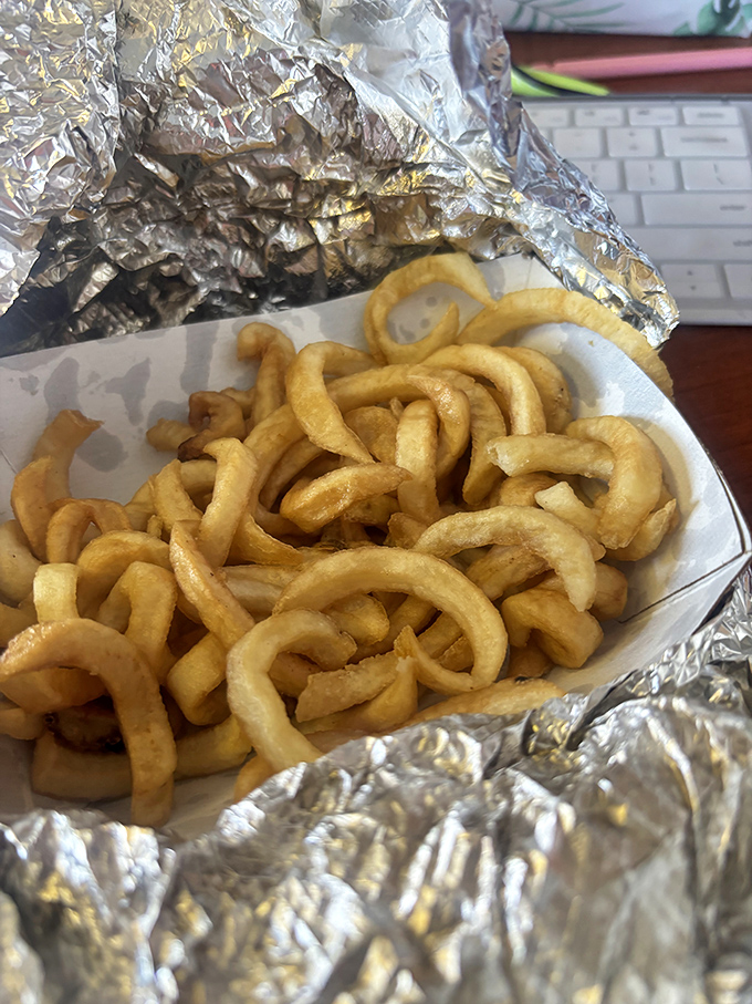 These aren't just curly fries&mdash;they're golden, crispy corkscrews of potato perfection, nestled in foil like the treasure they truly are.