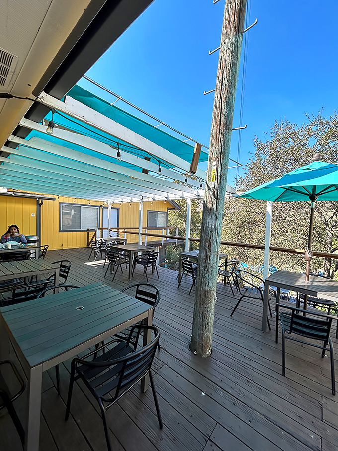 The blue canopy creates an oasis of shade where hungry hikers and locals alike escape the mountain sun while plotting their next sandwich conquest.
