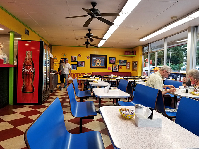 The dining area hums with the sound of satisfaction, where blue chairs and yellow walls create the perfect backdrop for breakfast bliss.