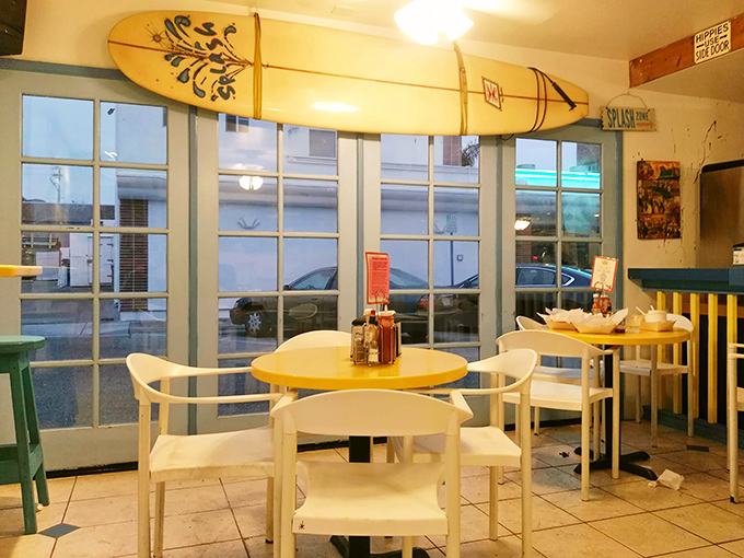 Surfboards watch over diners like benevolent ocean guardians in this sunny corner where yellow tables brighten even foggy mornings.