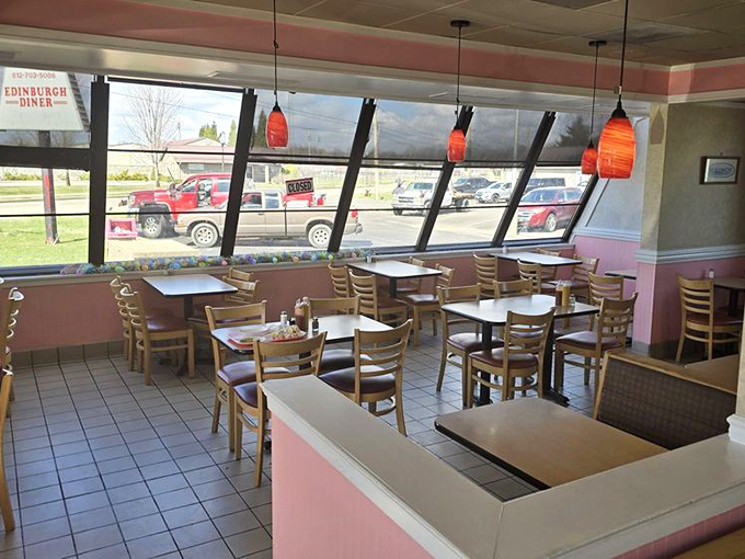 Pink walls and pendant lights create that distinctive diner glow. Every booth holds the promise of a meal worth remembering.