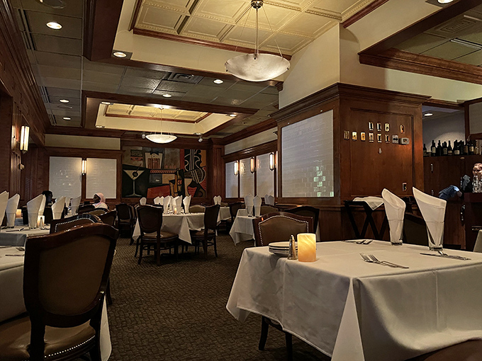 White tablecloths and warm wood paneling create that rare atmosphere where you feel simultaneously pampered and completely at home.