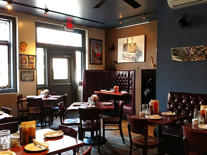Deep blue walls, leather booths, and carefully curated art create a dining room that feels both timeless and perfectly of-the-moment.