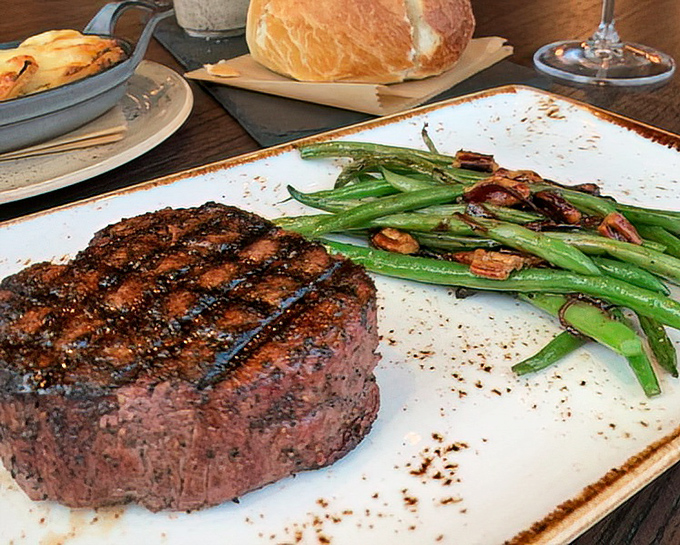 This filet showcases wood-fired mastery with asparagus spears that maintain perfect texture, creating steakhouse excellence on every plate.