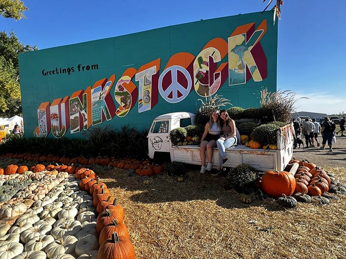 The "Greetings from Junkstock" mural serves as the perfect backdrop for memories, surrounded by a sea of pumpkins in autumn splendor.