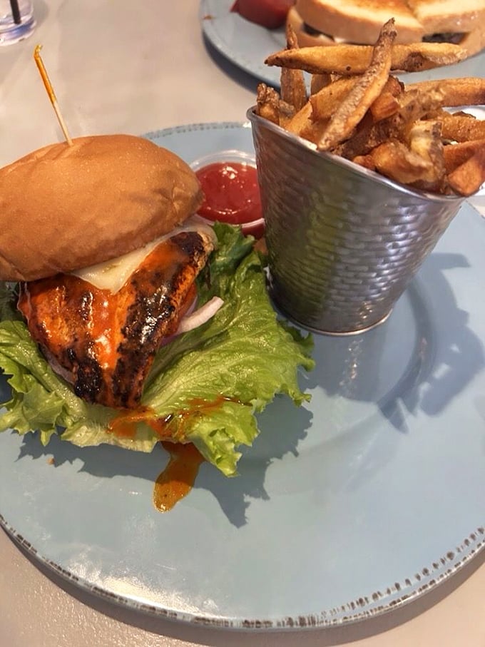 This grilled buffalo chicken sandwich, served with a metal bucket of fries, is what your doctor warned you about—and your taste buds dreamed of.
