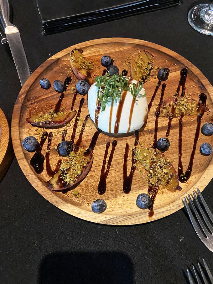 A wooden stage for grilled peaches and burrata's delicate dance. Those balsamic drizzles aren't just decoration—they're flavor lightning bolts zigzagging through paradise.
