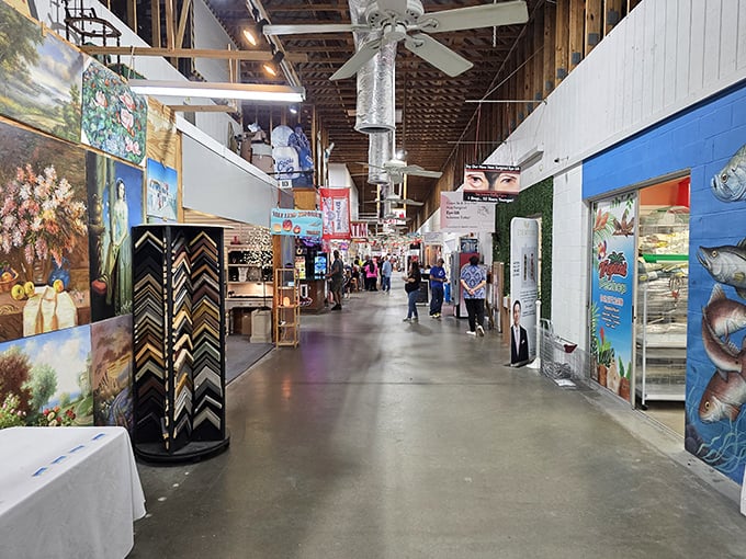 Art frames the walkway like a gallery where everything has a price tag. The high ceilings and exposed beams give this commercial space an unexpectedly cathedral-like quality.