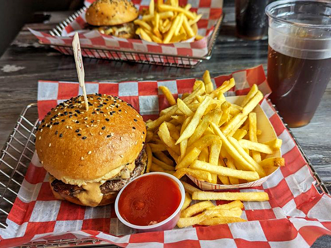 Burger perfection in its natural habitat. The sesame-studded bun crowns a masterpiece that makes fast food drive-thrus seem like a sad compromise.