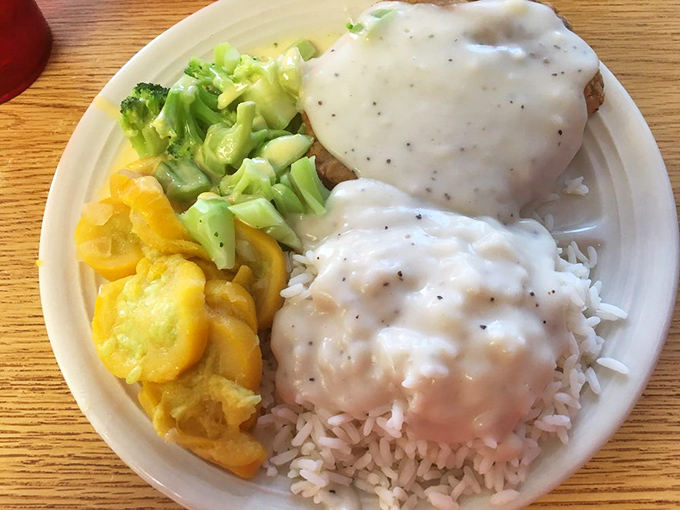A plate that says "Louisiana knows comfort food." Rice smothered in gravy, tender chicken fried steak, and vegetables that didn't come from a freezer.