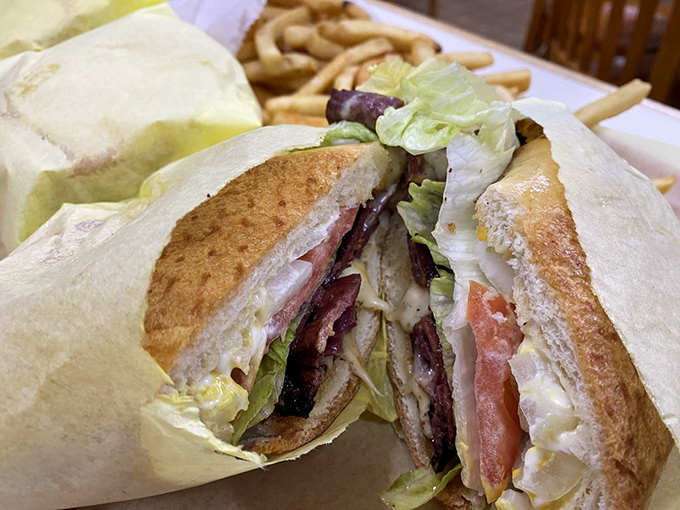 The club sandwich, stacked higher than some Manhattan apartments, delivers three stories of flavor with a side of nostalgia.