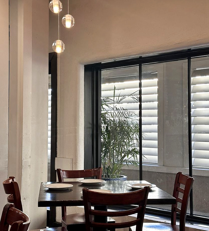 Minimalist elegance with natural light flooding through windows, creating a peaceful corner perfect for savoring both food and conversation.