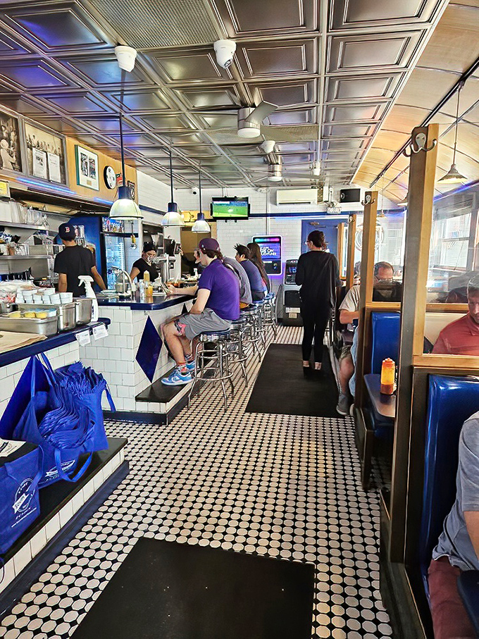 The diner's interior is a time capsule with modern comforts—classic penny tile floors and pressed tin ceilings frame a bustling breakfast ballet.