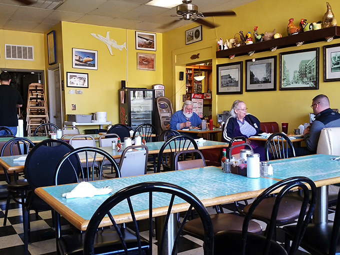 Turquoise tables, black and white floors, and yellow walls create the holy trinity of classic diner aesthetics. No interior designer required.