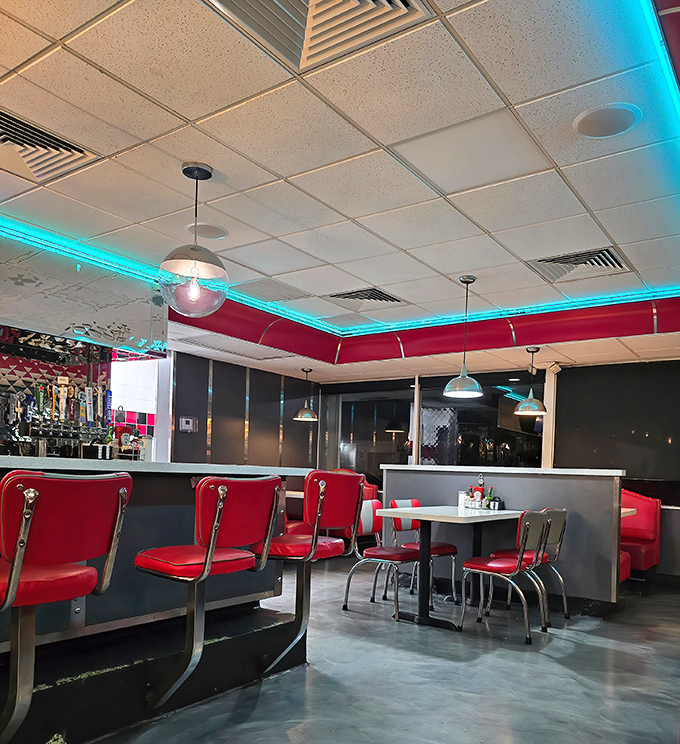 The turquoise neon glow against classic red booths creates that perfect retro vibe&mdash;Edward Hopper would've added this scene to his collection.
