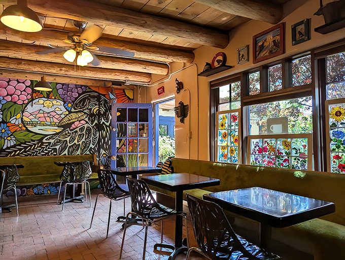 Where coffee meets culture. The vibrant mural, wooden beams, and colorful windows create a space that feels more like an artistic sanctuary than a caf&eacute;.