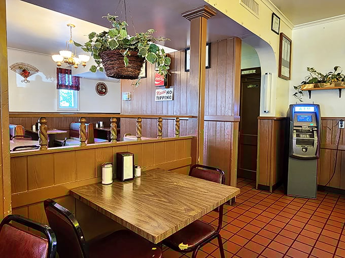 Hanging plants and wood paneling create that perfect "grandma's dining room meets small-town diner" vibe that no designer could replicate.