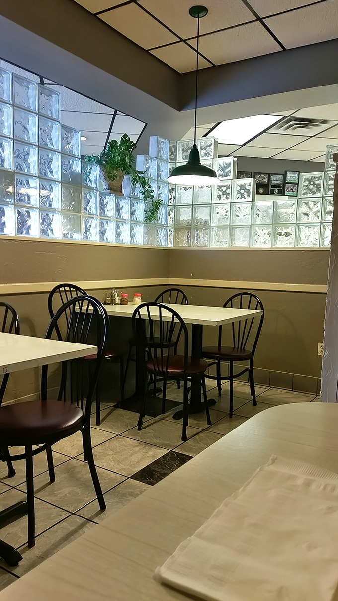 Simple elegance in dining—glass blocks filtering light, classic chairs, and tables set for memorable meals where conversations matter as much as the cuisine.