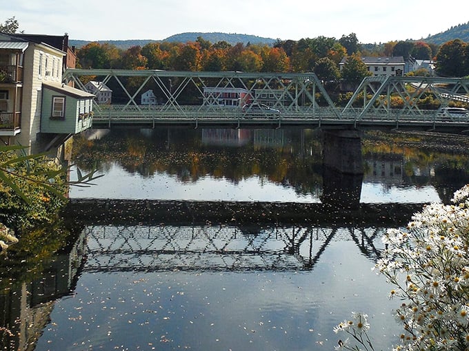 This iron bridge has carried generations across the Deerfield River, its reflection creating perfect symmetry that would make a mathematician swoon.