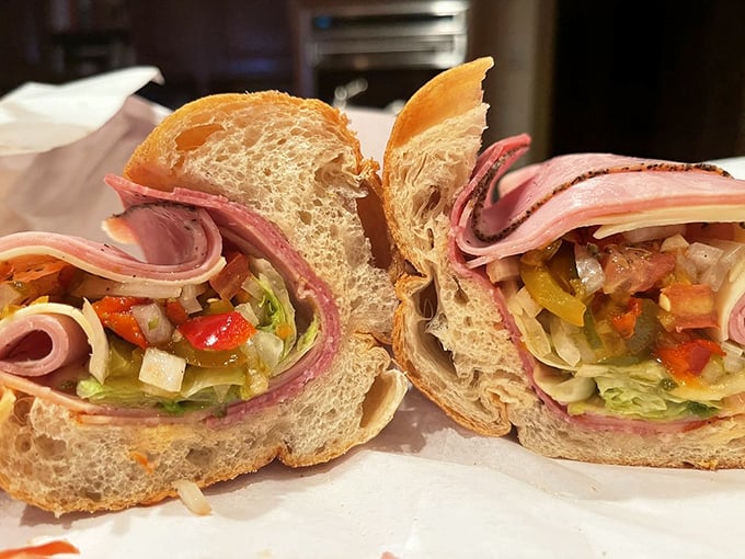 The Italian sub, sliced with surgical precision, offers a colorful cross-section of deli artistry that would make Renaissance painters put down their brushes.